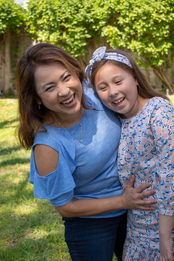 Latina Mother and Daughter Smiling and Laughing Outside in Back Yard ...