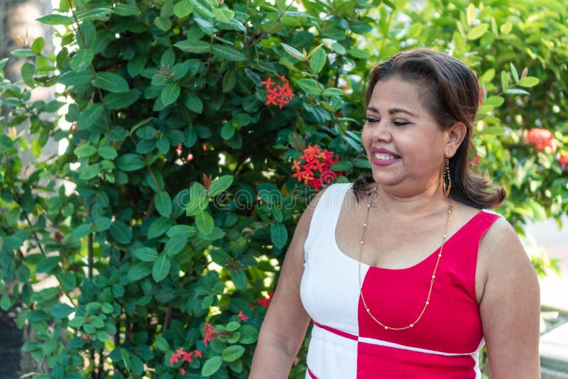 Latina Woman in Her 50`s Posing in the Sunlight with Red Flower Stock ...