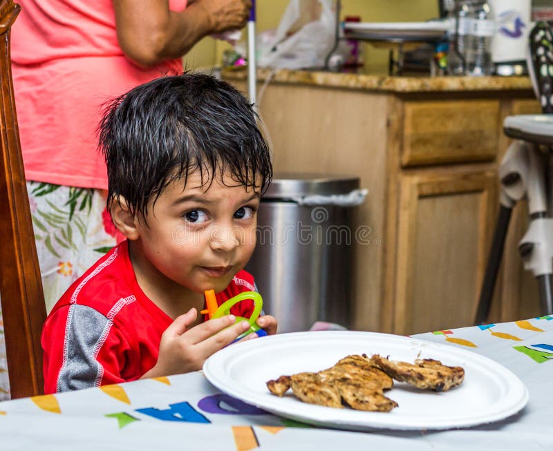 Latino Child Sitting at a Table with Food Stock Photo - Image of meal ...