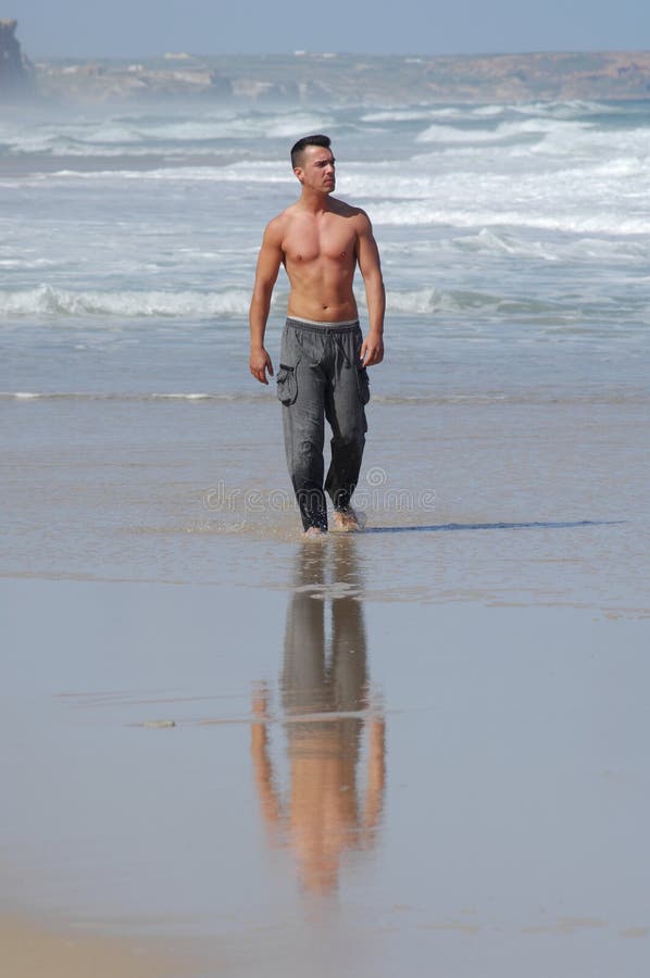 Latino Man Walking on a Beach Stock Photo - Image of looking, outdoors ...