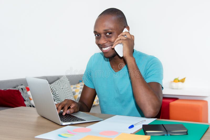 Laughing African American Man Working with Computer and Speaking Stock ...