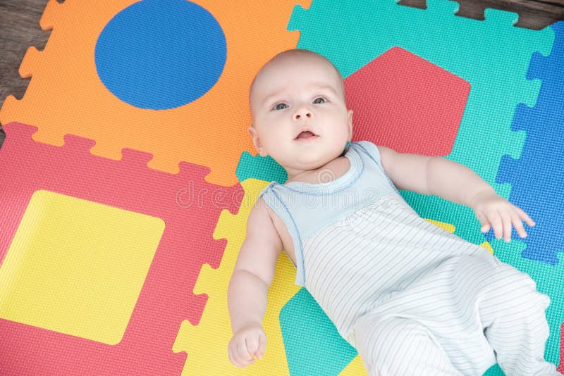 Laughing Child on a Colored Rubber Mat Puzzle for Playing Foam with ...
