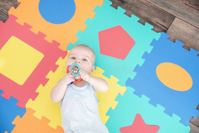 Laughing Child on a Colored Rubber Mat Puzzle for Playing Foam with ...