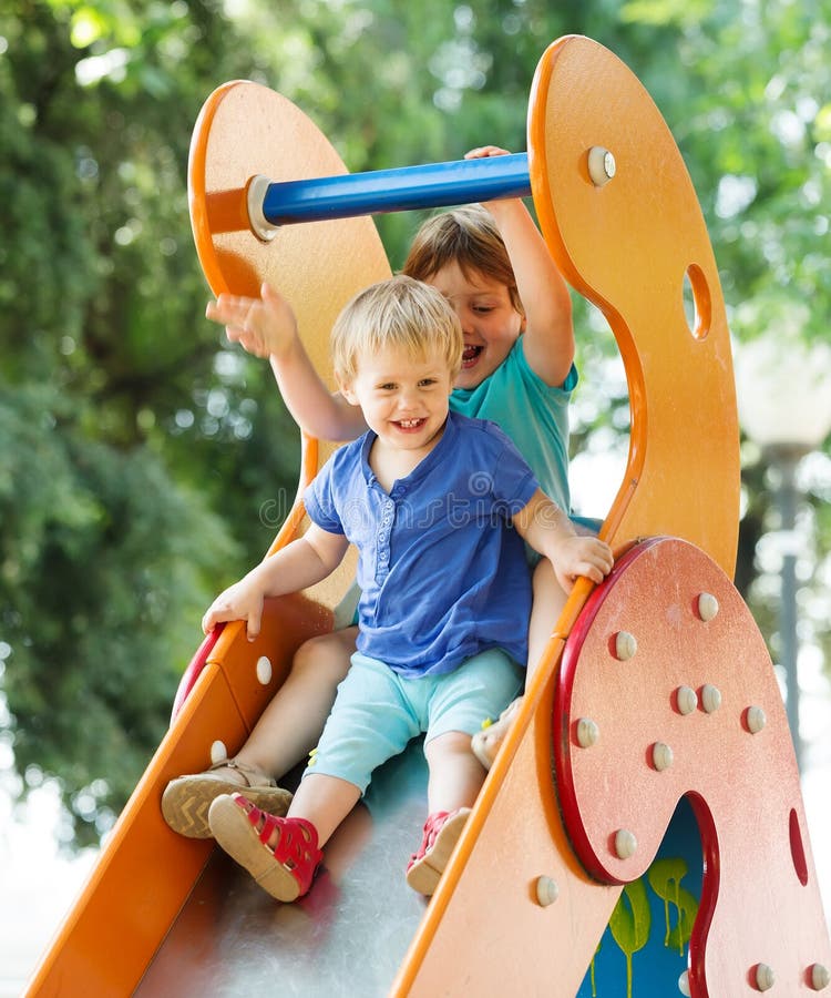 Laughing children on slide stock photo. Image of smile - 57526454