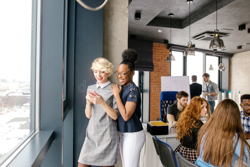 Laughing Co-workers Using Smart Phone during Break at Work Stock Image ...