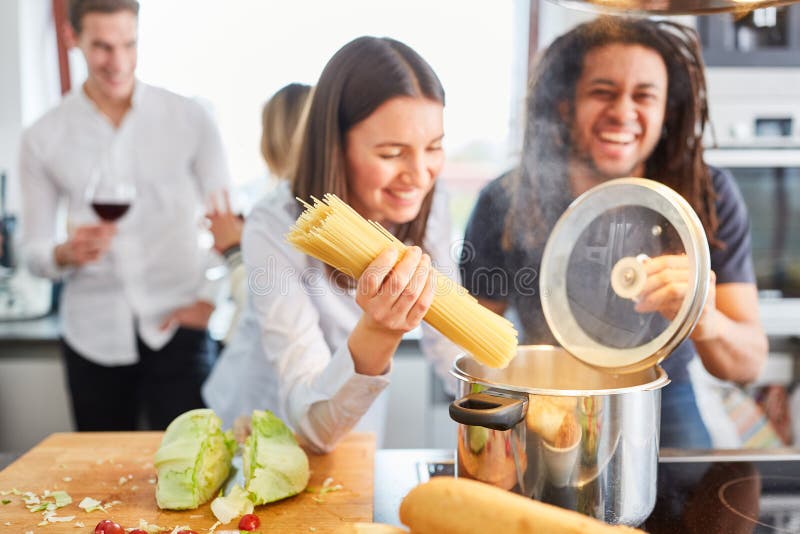 Happy Friends Cook Spaghetti Pasta Together in Kitchen for Lunch Stock ...