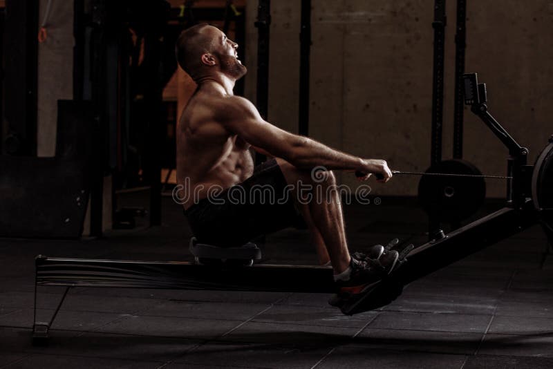 Laughing Guy is Developing His Muscles with Indoor Rower. Stock Photo ...