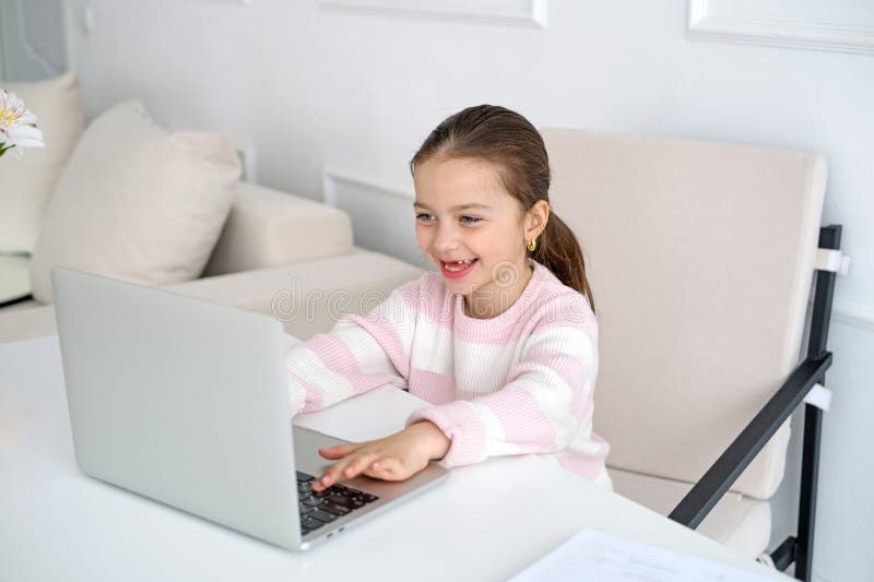 A Laughing, Happy Girl is Sitting in Front of Computer Playing Video ...