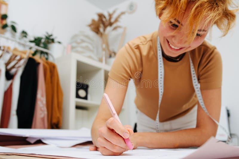 Laughing Tailor Girl, she Works in the Studio, Taking Notes in a ...