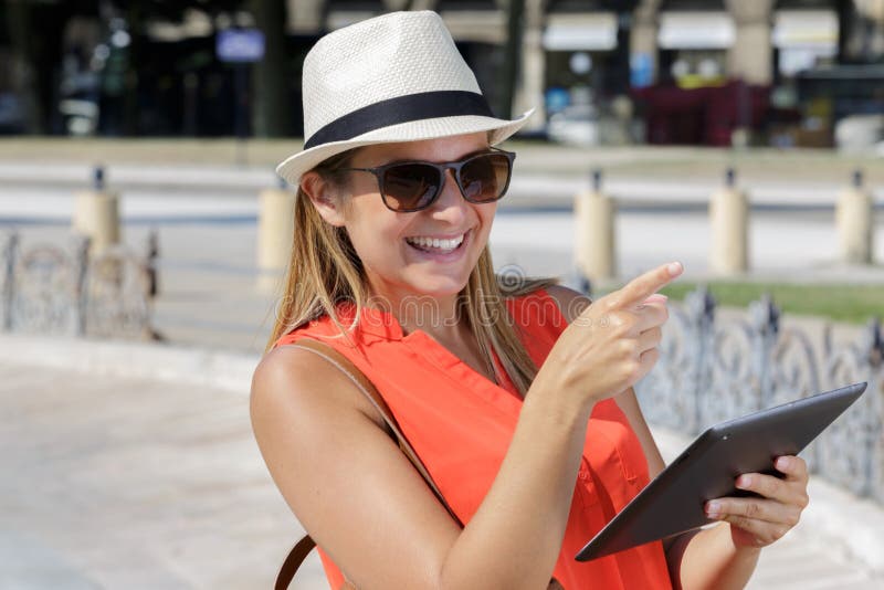 Laughing Woman Holding Tablet and Pointing into Distance Stock Photo ...