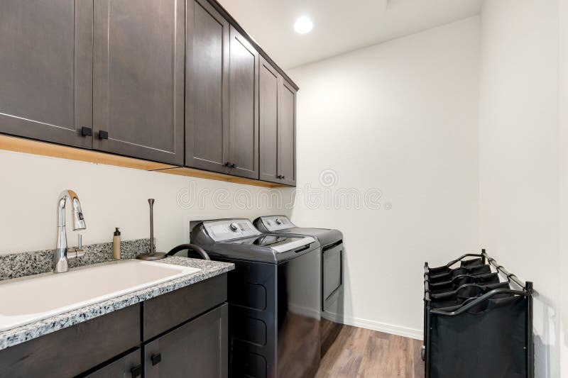 A Laundry Room Equipped with a Washer, Dryer, and a Sink Present Stock ...