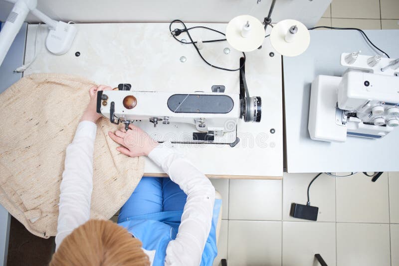 The Laundry Worker Performs Repair of Clothing on the Sewing Machine ...