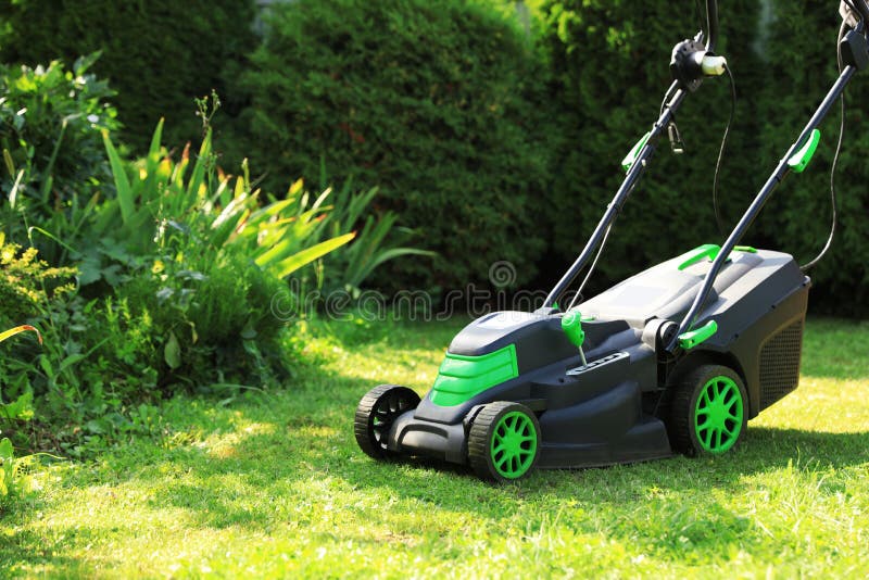 Lawn Mower on Green Grass in Garden Stock Photo - Image of green ...