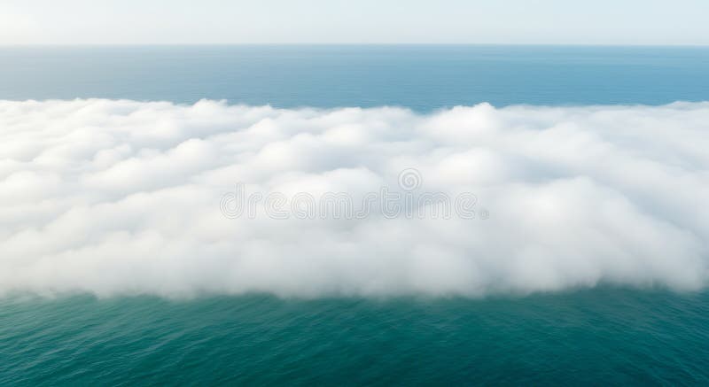 A Layer of Fluffy, White Clouds Hugs the Surface of a Vast Blue Ocean ...