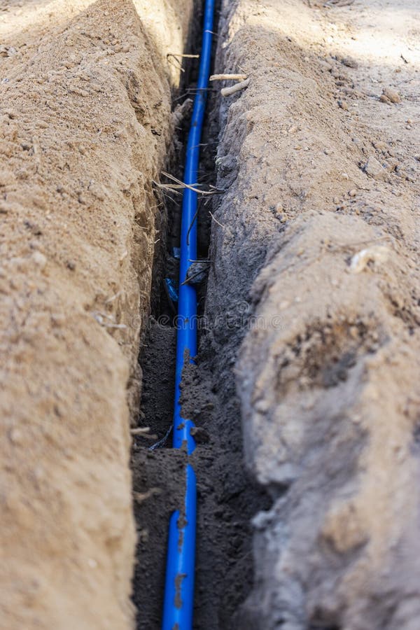 Laying a Blue Electrical Cable in a Trench in the Ground. Underground ...