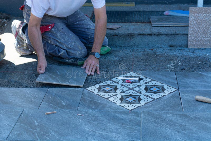 Man laying floor tiles stock image. Image of fliesen - 212786249