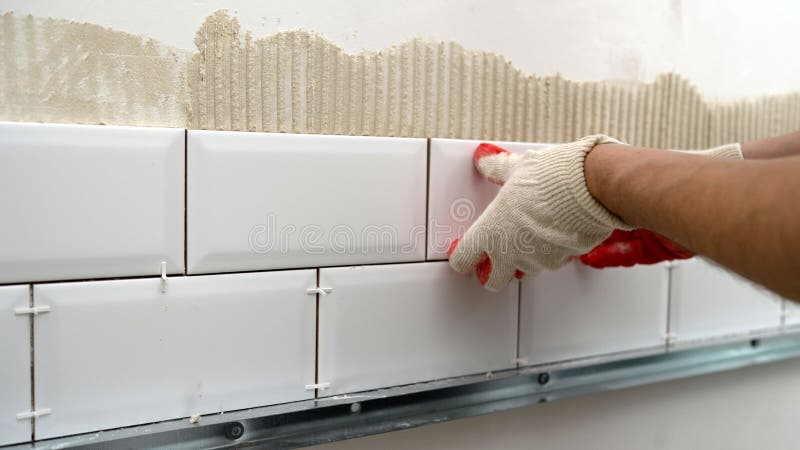 A Worker Lays and Installs White Ceramic Tiles in a Kitchen. Ceramic ...