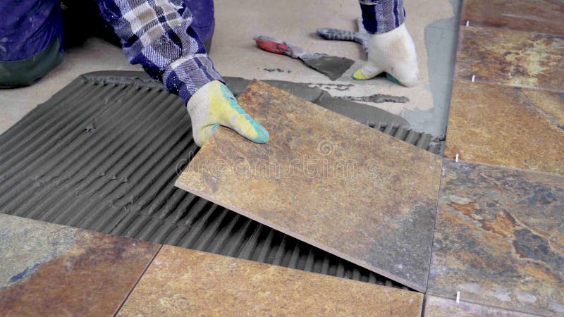 Laying Ceramic Tiles on the Floor, the Master Puts the Tile on the Tile ...