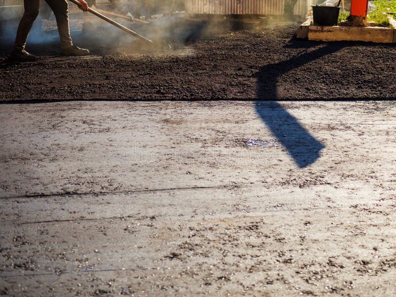 Laying New Asphalt. the Process of Leveling the Asphalt Manually Using ...