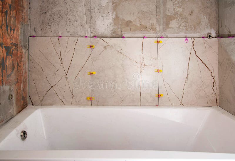 Laying Porcelain Tiles on the Wall in the Bathroom. Modern Tile ...