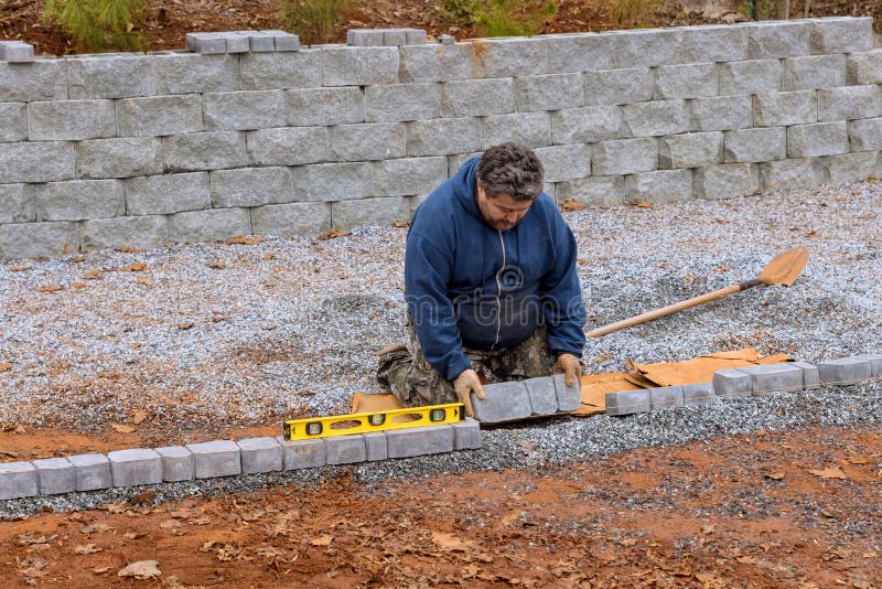 Laying Stone Concrete Pavers for a Sidewalk by Construction Workers ...