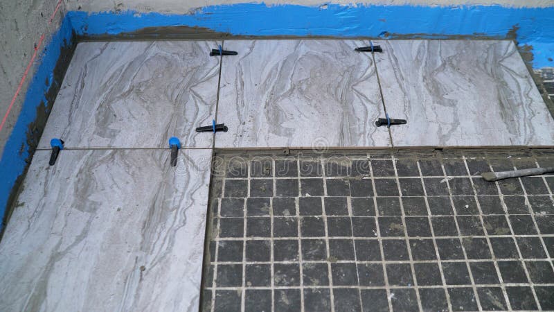 Laying Tiles in the Bathroom Over Old Tiles. Renovation Work in the ...