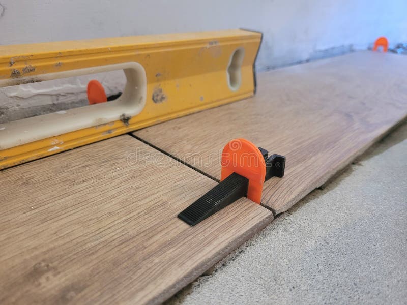 Laying Tiles at Home. Leveling Floor Tiles with a Level Stock Image ...