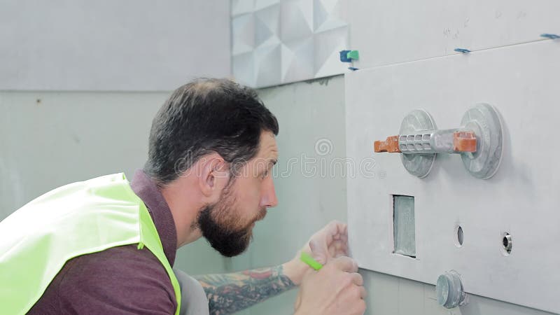 Laying Tiles. Meister Priming the Tiles before Laying Them on the Wall ...