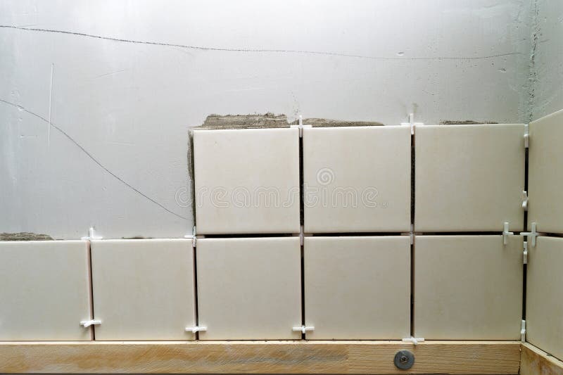 Laying White Ceramic Tiles on the Wall Using Crosses Stock Image ...