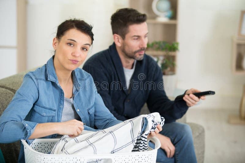Lazy Man with Remote Control and Wife with Laundry Basket Stock Image ...