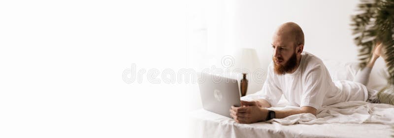 Lazy Man Using Social Media on Laptop in Bed. Working Remote with ...