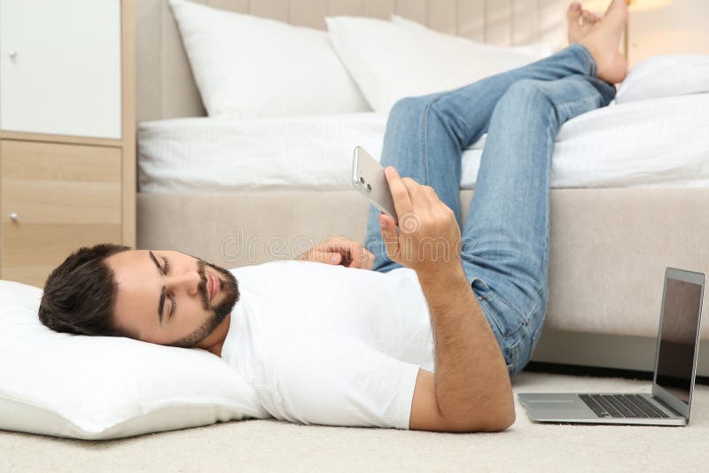 Lazy Man with Laptop and Smartphone Lying on Floor at Home Stock Image ...