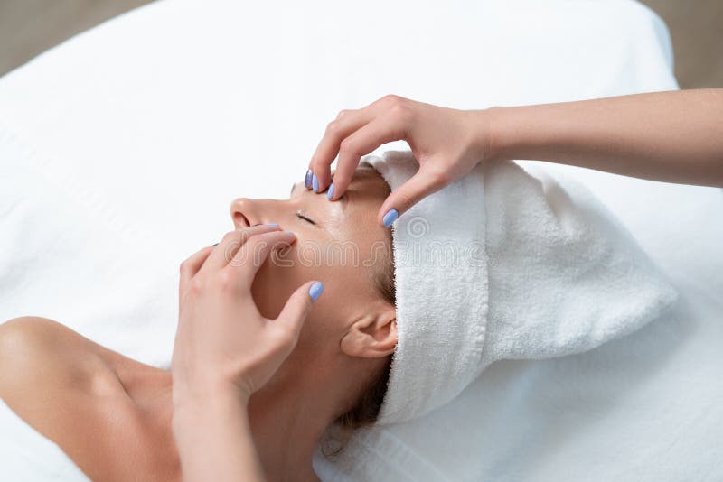 Dame Attirante De Sourire Atteignant Le Massage De Visage Le Salon De