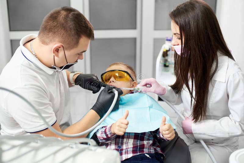 Un Enfant Montrant Des Pouces Tout En Faisant Soccuper Ses Dents Par