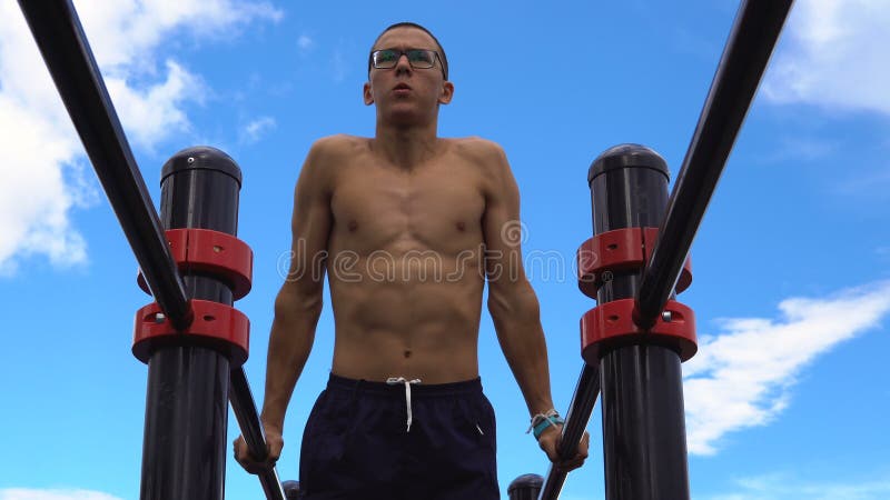 A Lean and Muscular Guy Trains on Workout Bars. Stock Video - Video of ...