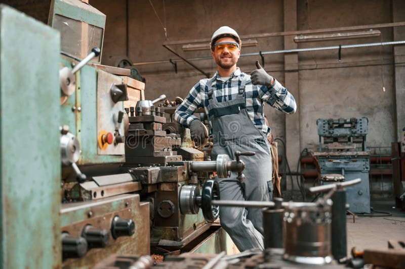 Leaning on the Factory Machine and Showing Thumb Up. Worker in Uniform ...