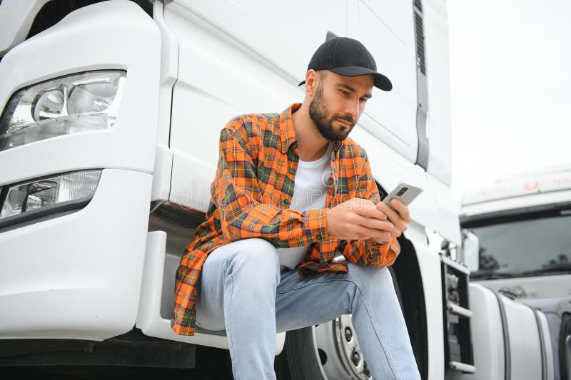Leaning by the Vehicle and Using Phone. Young Truck Driver is at ...