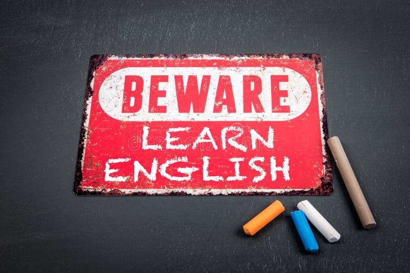 Learn English. Beware Sign with Text and Colored Pieces of Chalk on a Dark Chalkboard Background ...