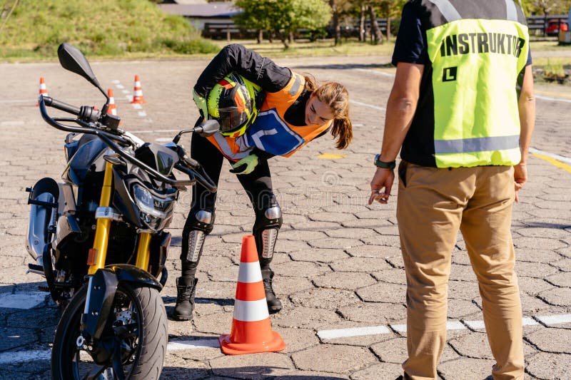 Learner Biker on Test Road with Red Cones. Instructor Writing on ...
