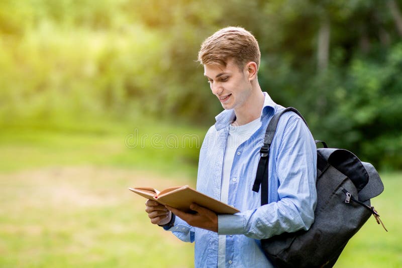 Learning Concept. Handsome Student Guy Reading Book Outdoors, Resting ...