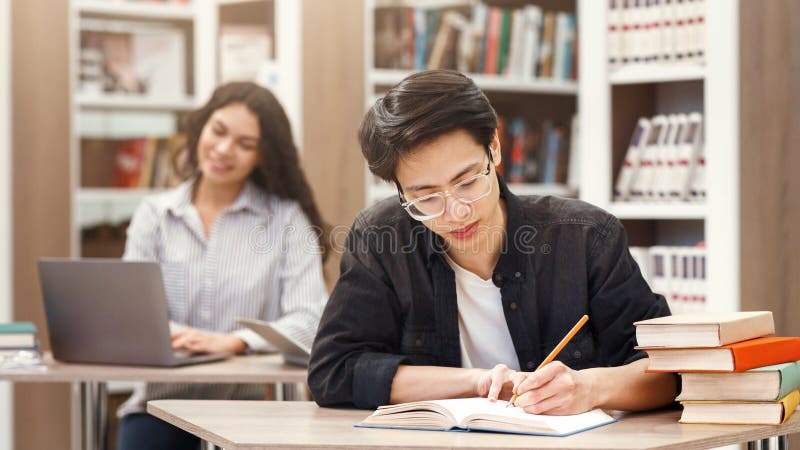 Asian Guy Doing Research Sitting at Desk in Library Stock Image - Image ...