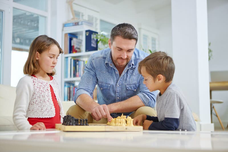 Learning the Game. a Father Playing a Game of Chess with His Son and ...