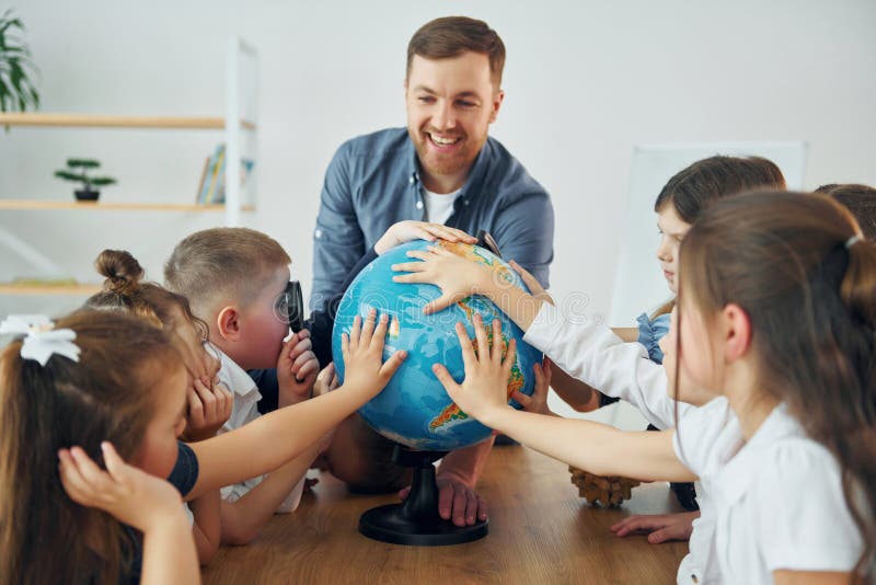 Learning Geography by Using Earth Globe. Group of Children Students in ...