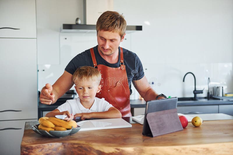Learning How To Cook. Father and Son is Indoors at Home Together Stock ...