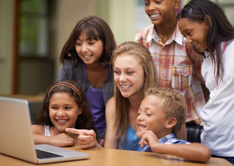 Learning More about Computers. a Group of Pupils Working on a Laptop in ...