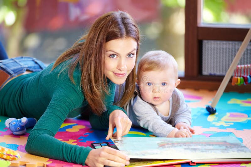 Mom and Son Playtime. Cute Young Mom Sitting Alongside Her Infant Son and Holding Him while he ...