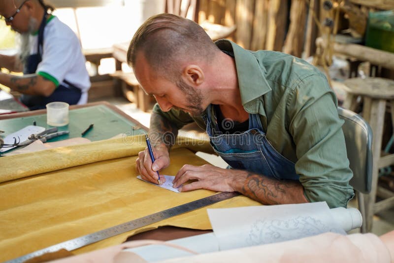 Leather Craftsman Using a Pencil Drawing Draft Design on the Yellow ...