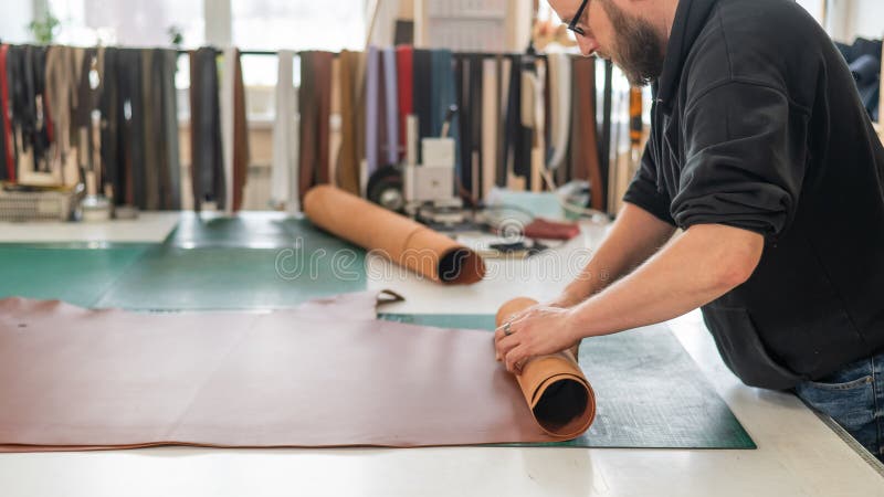 Leatherworker Unrolls Rolls of Leather in Workshop. Stock Photo - Image ...