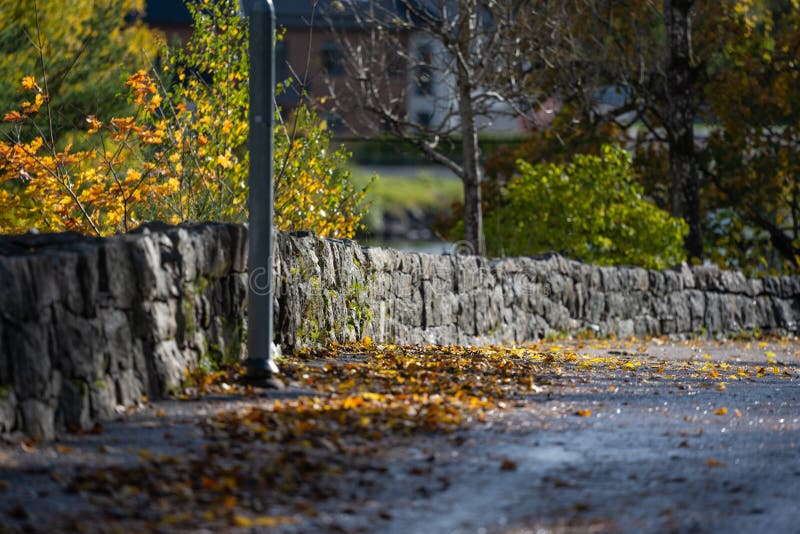 Leaves by a Low Stone Wall by a Road at Fall.. Stock Image - Image of ...