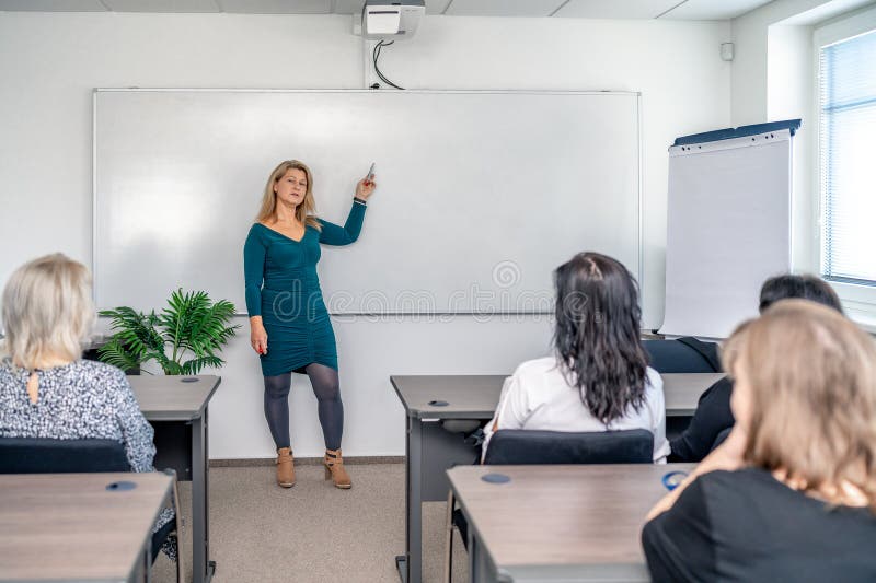 The Lecturer Gives a Lecture in Front of the Whiteboard at the Training ...